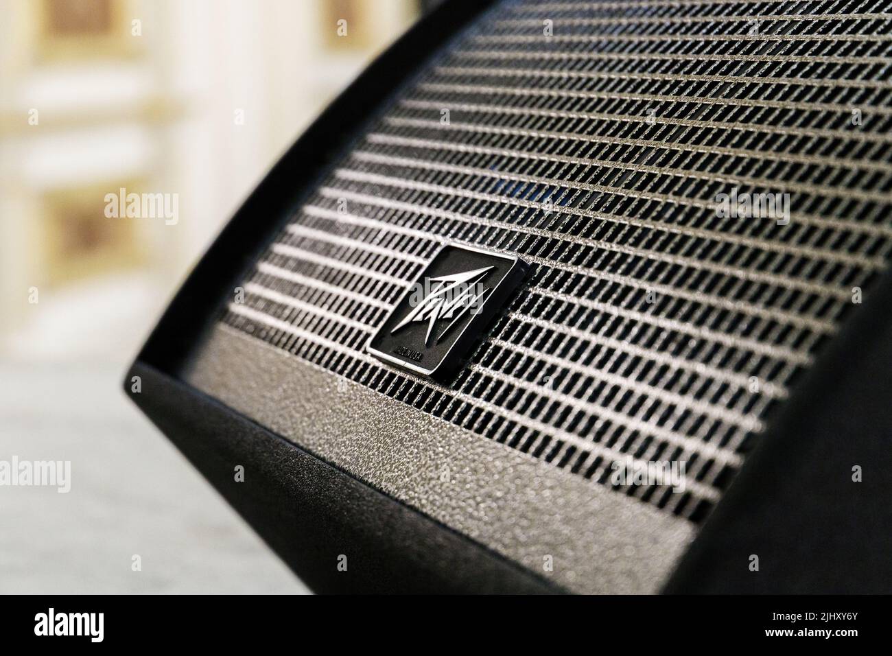A floor-standing peavey sound monitor stands on the stage in the ...