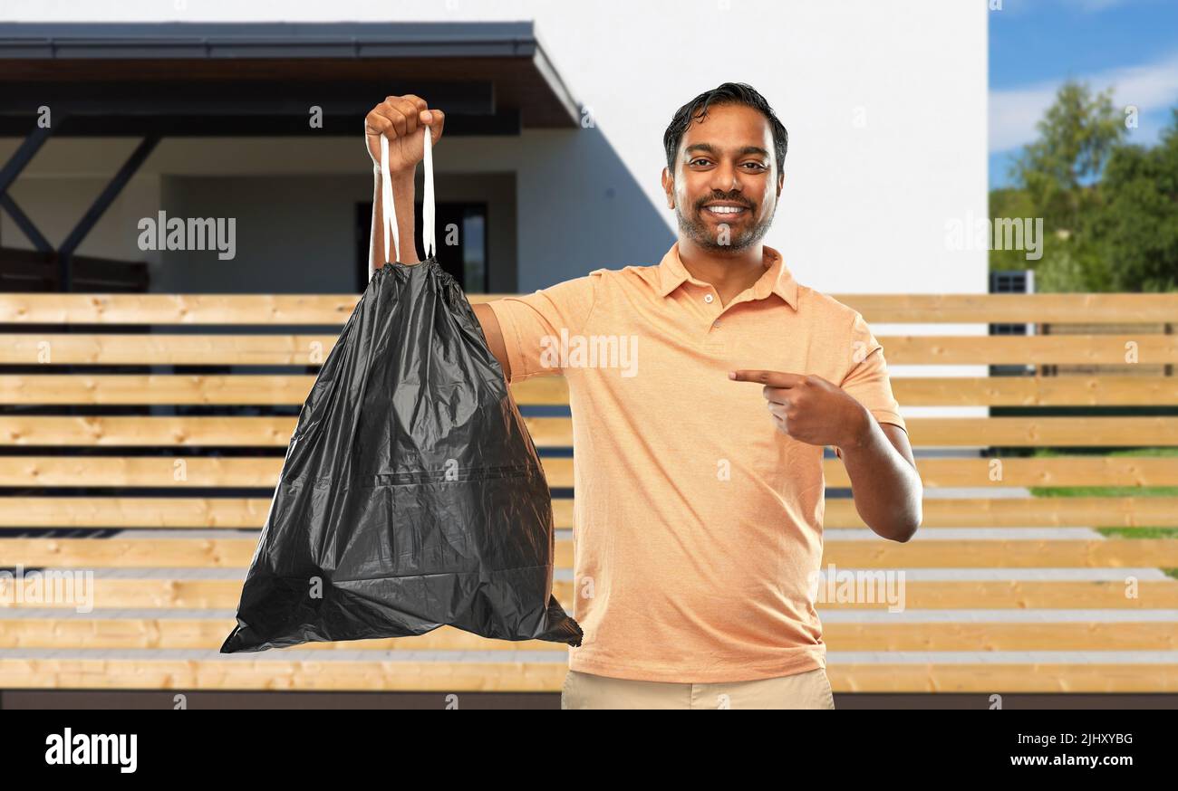 smiling indian man holding trash bag Stock Photo - Alamy