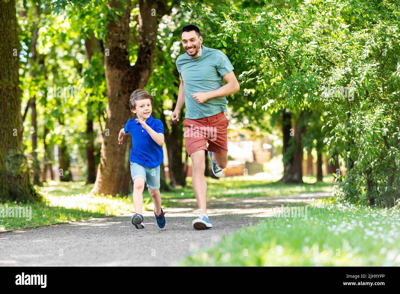 happy father and son compete in running at park Stock Photo - Alamy