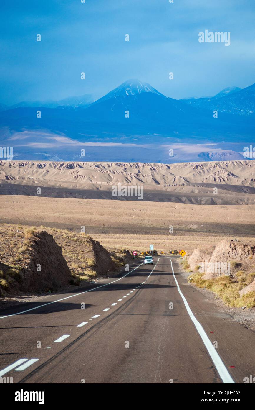A vertical shot of cars on asphalt turning road in the Atacama Desert ...