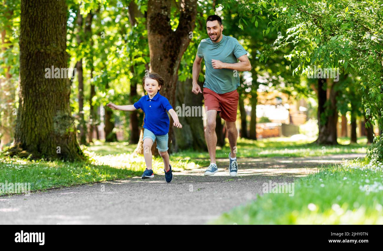 happy father and son compete in running at park Stock Photo - Alamy