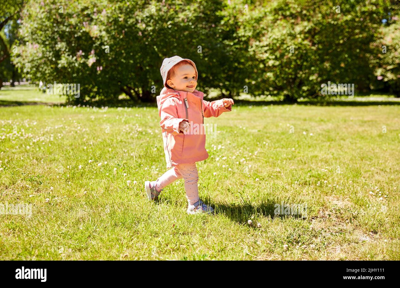happy little baby girl walking at park in summer Stock Photo - Alamy