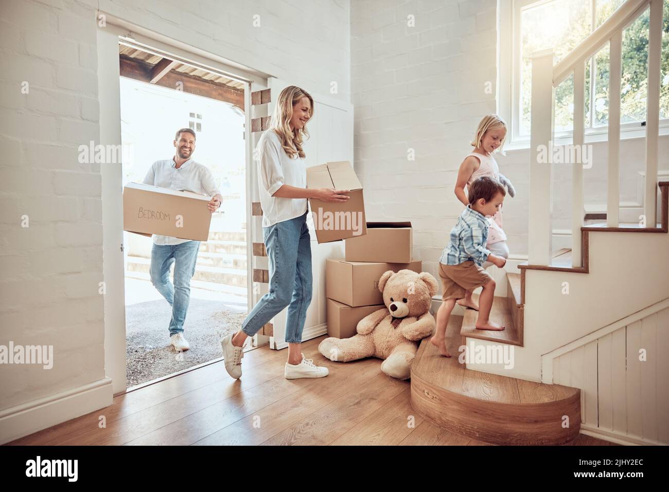 Happy caucasian parents with little kids moving into their new home ...