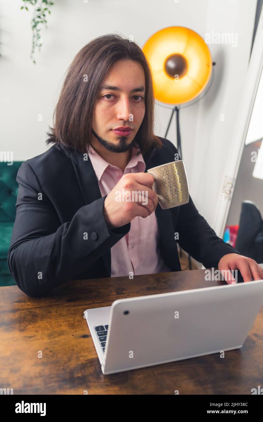 An adult man sitting in the room, looking in the lens - business area ...