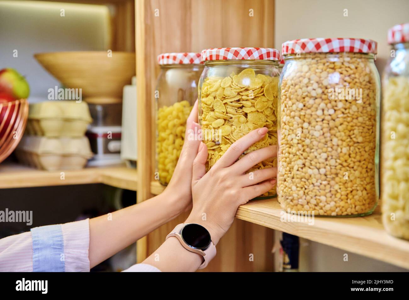 Storage of food in the kitchen in pantry, woman's hands with a can of ...