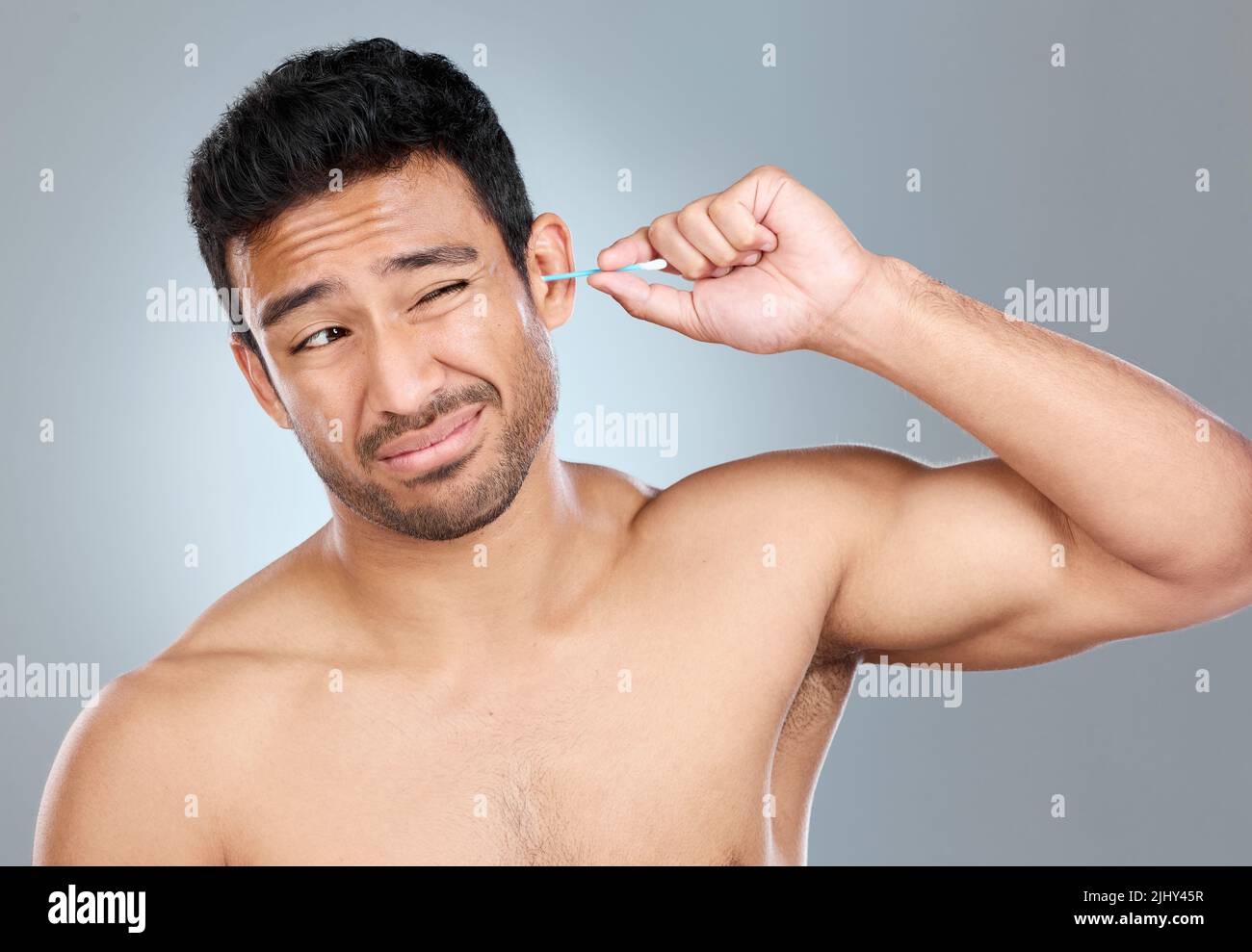Im trying not to go too deep. a man using a cotton bud to clean his ...