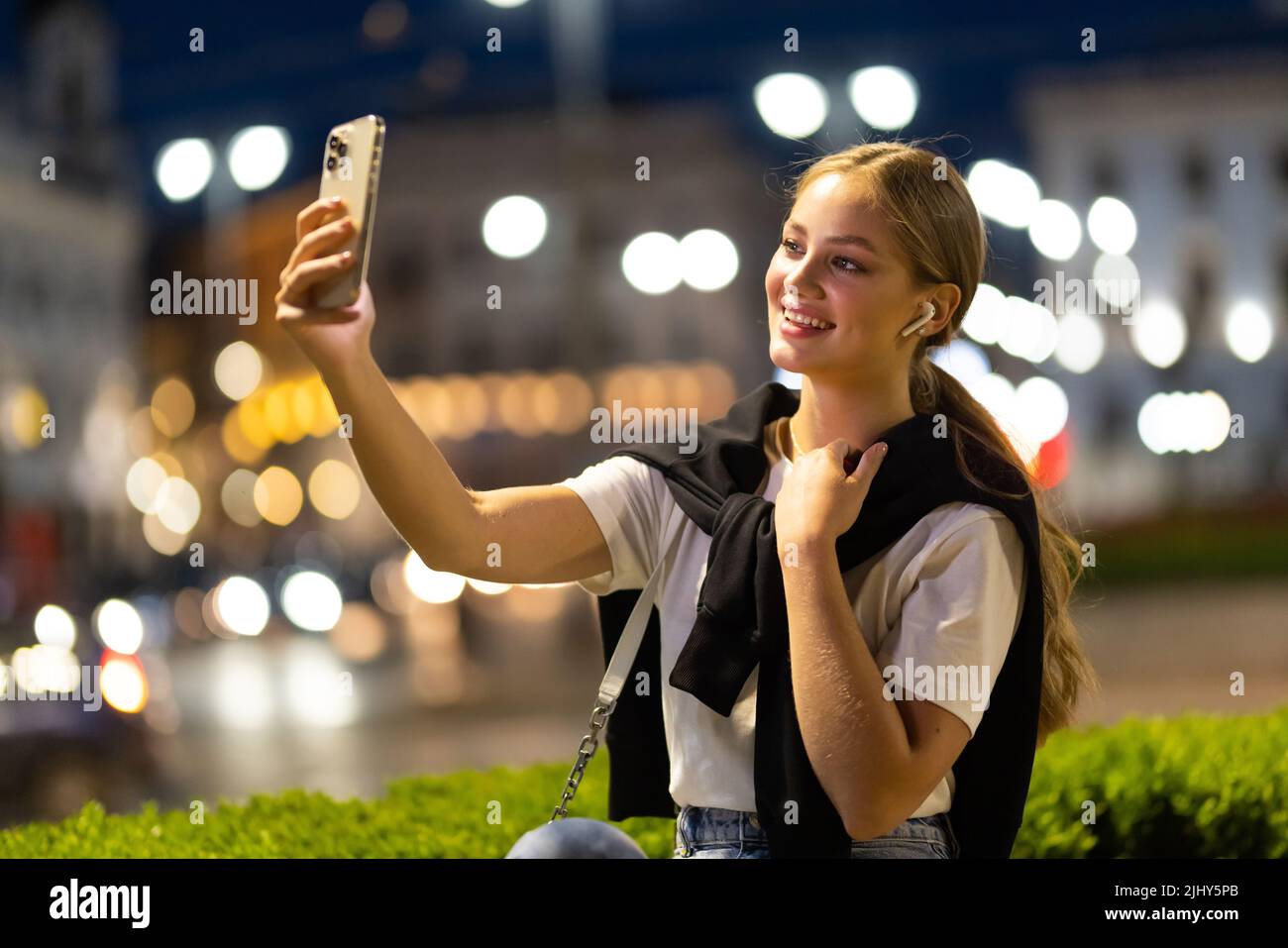 Lady makes a video call when she is outside in the city at night Stock ...