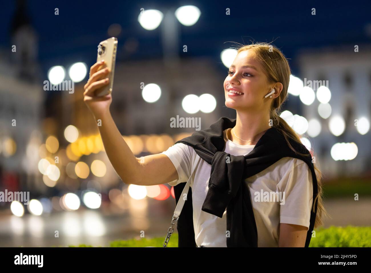 Lady makes a video call when she is outside in the city at night Stock ...
