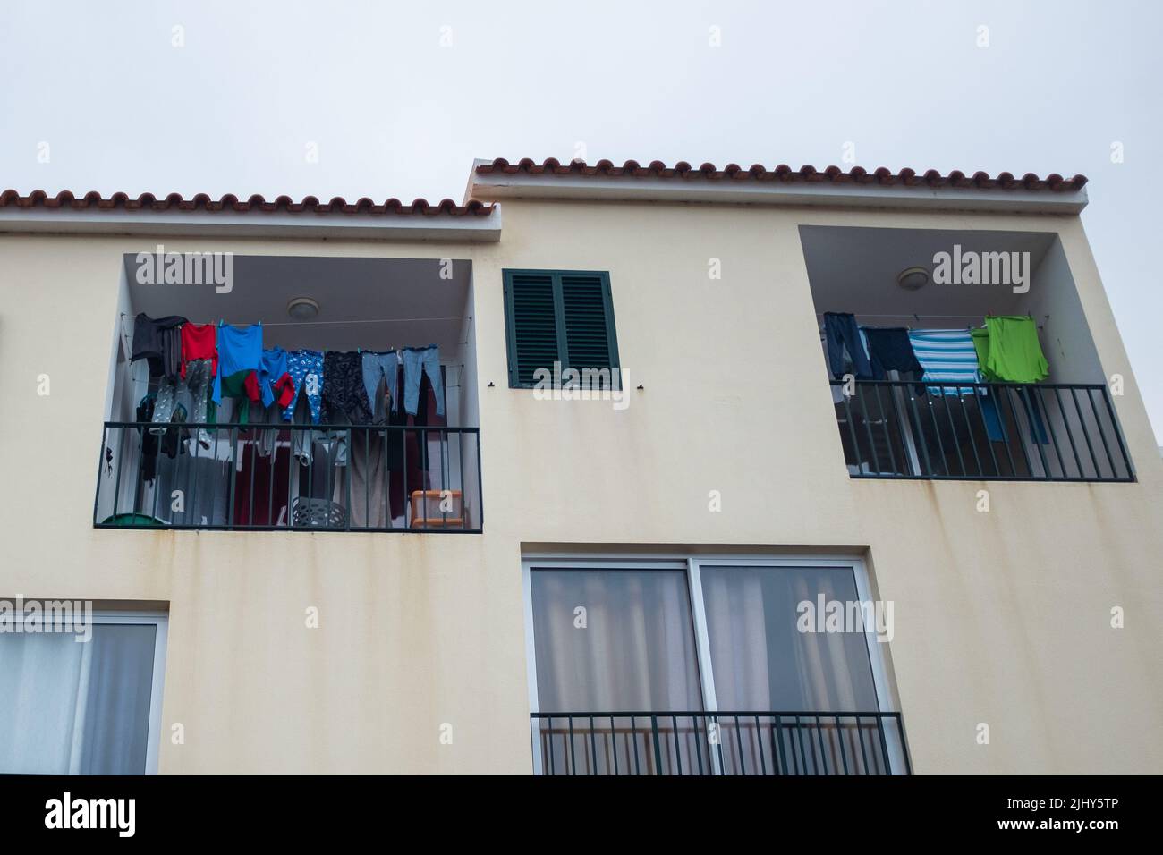 Laundry hangs to dry on a small balcony of an apartment building Stock ...