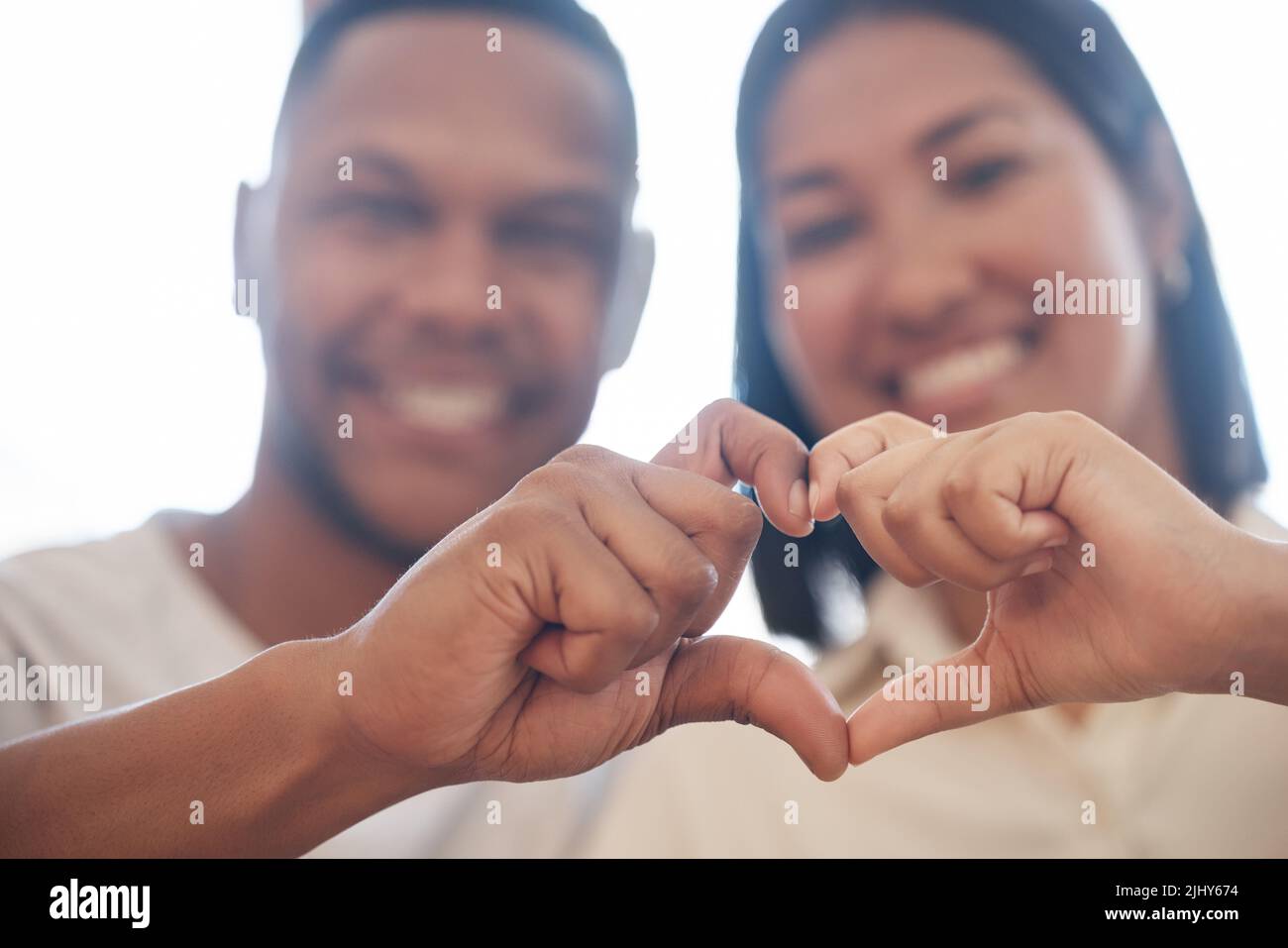 Closeup of happy mixed race couple forming heart shape with hands. Two ...