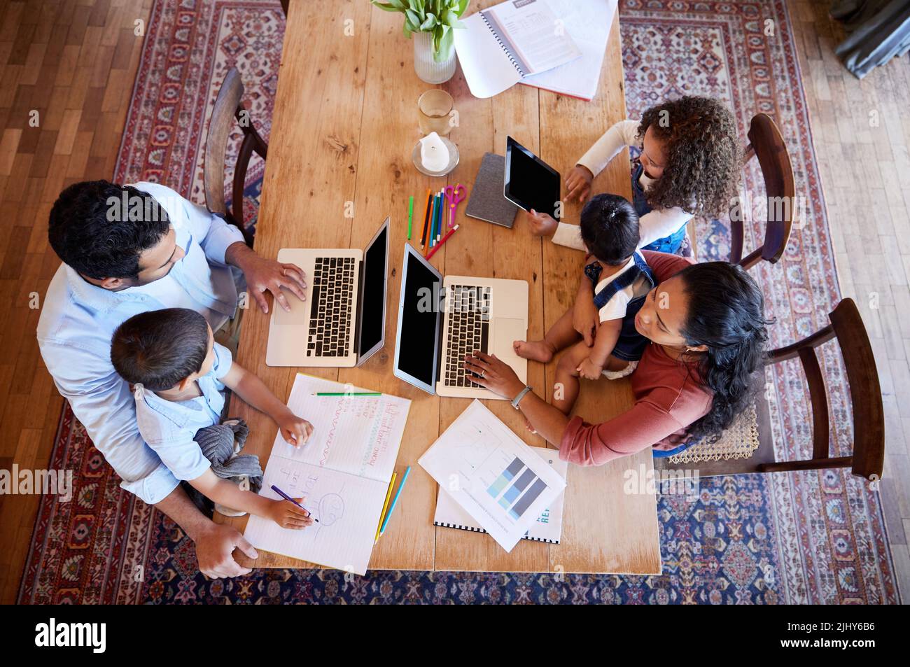 Above view parents working from home with kids. Couple working on ...