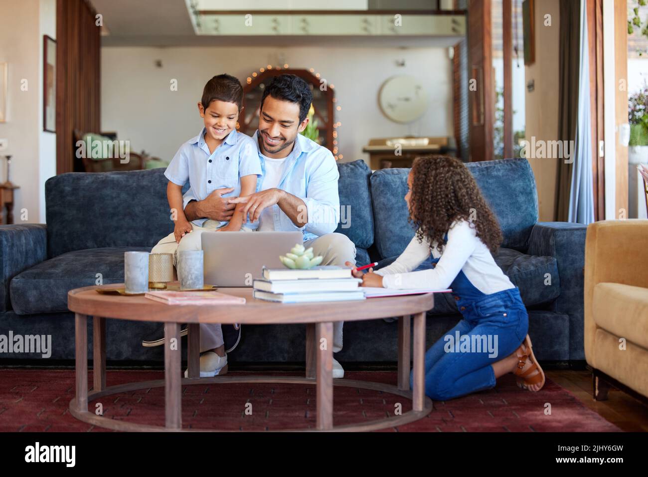 Father using a laptop at home with children. A happy dad online with ...