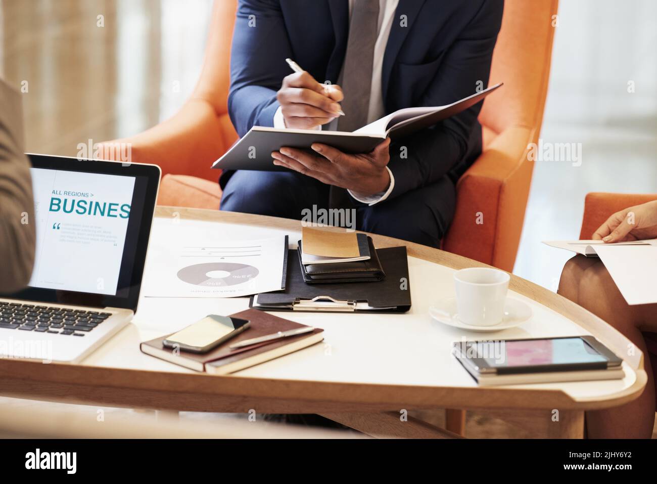 Group of diverse business people with laptops and notepads having a ...