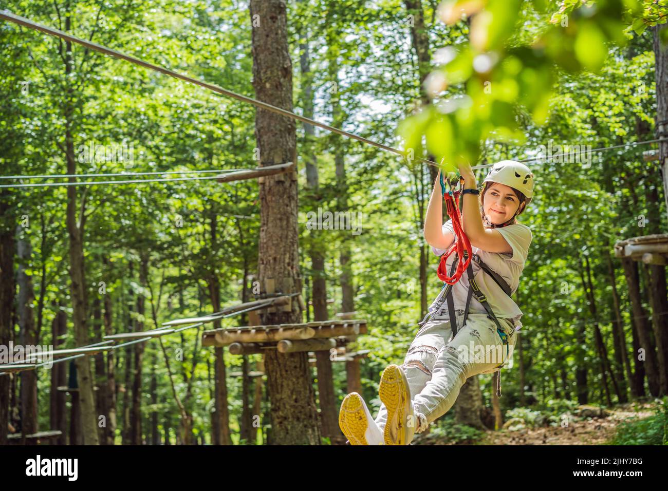 Happy women girl female gliding climbing in extreme road trolley ...
