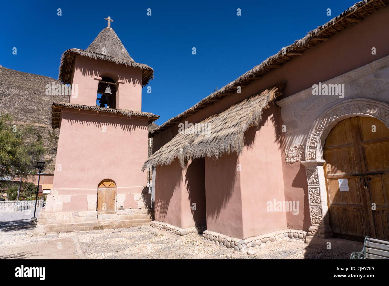 The bell tower and carved stone portal of the side entrance of the ...