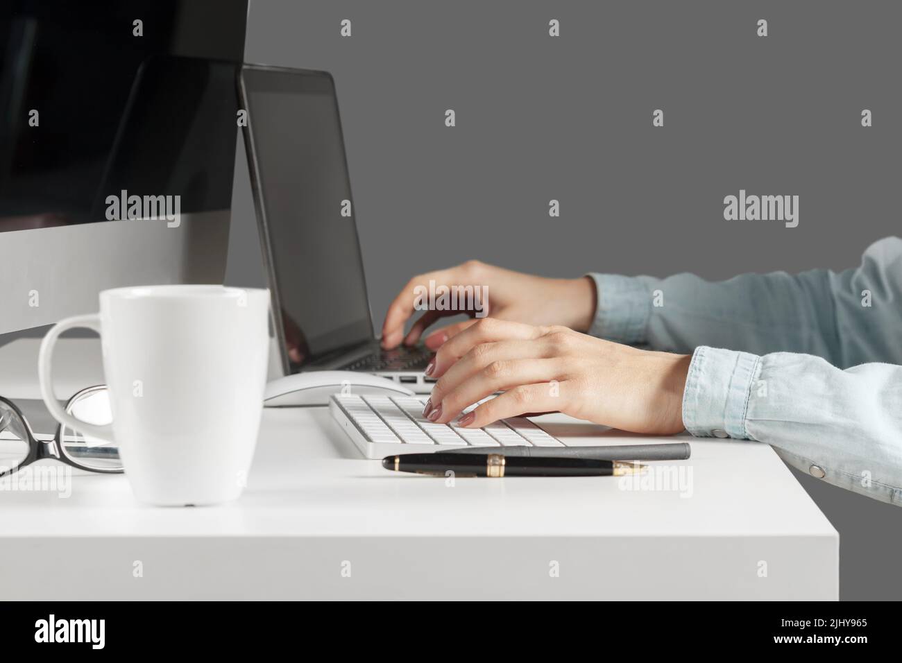 Young woman sitting at the table with open netbook computer. Female ...