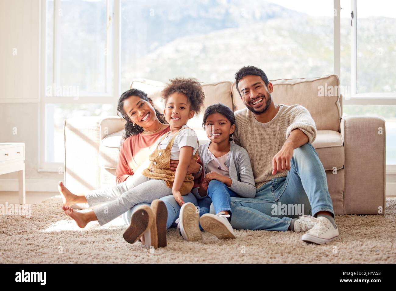 Portrait of two happy parents bonding with their daughters in the ...