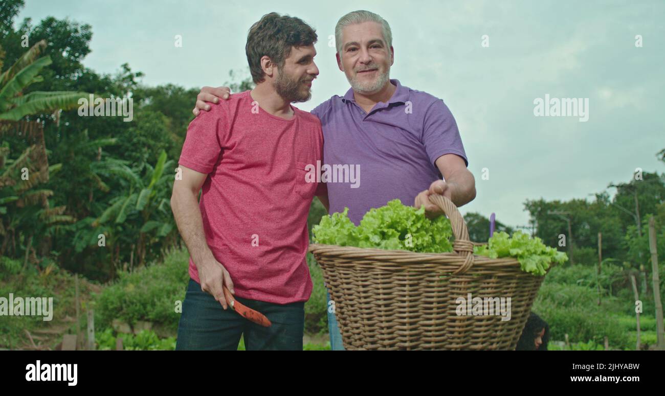 Two urban farmers posing for camera. Father and adult son portrait at ...