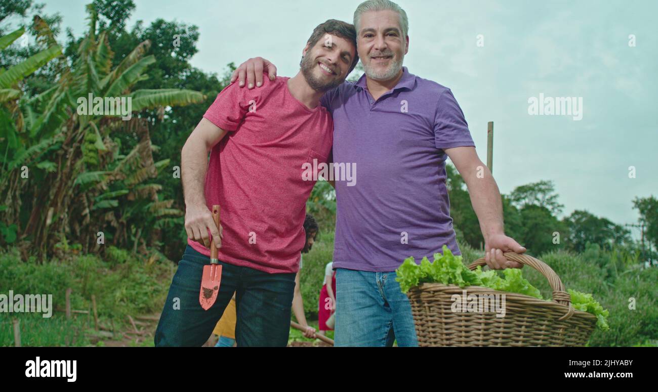 Two urban farmers posing for camera. Father and adult son portrait at ...