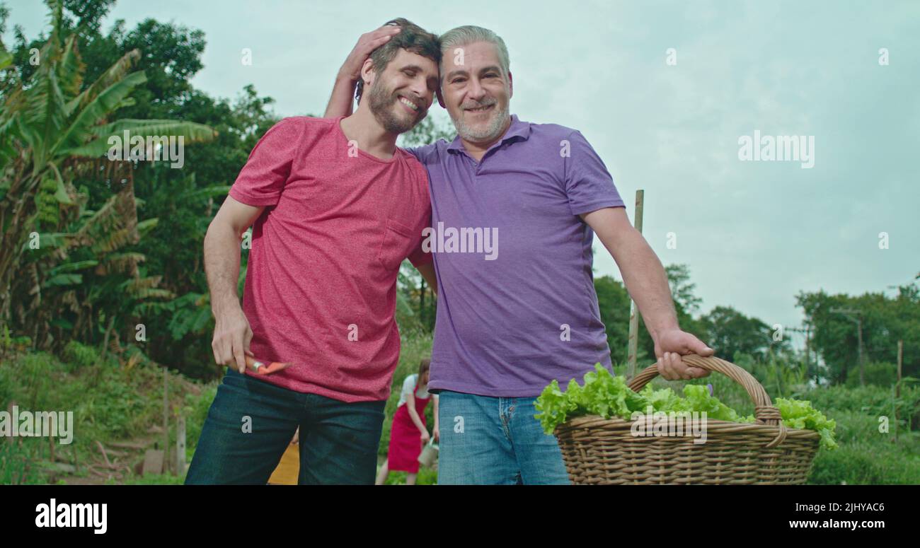 Two urban farmers posing for camera. Father and adult son portrait at ...