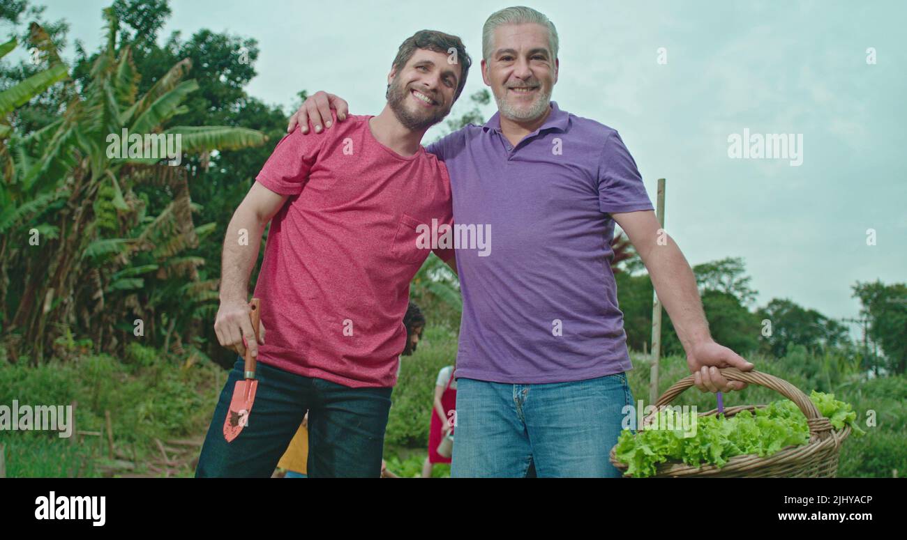Two urban farmers posing for camera. Father and adult son portrait at ...