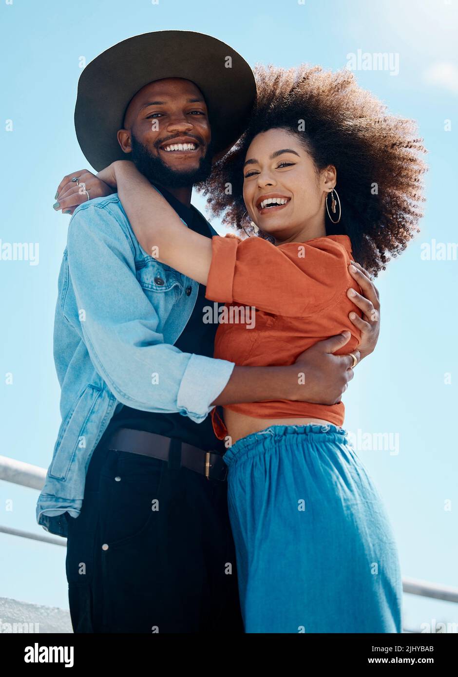 Portrait of two young diverse people embracing and smiling while ...