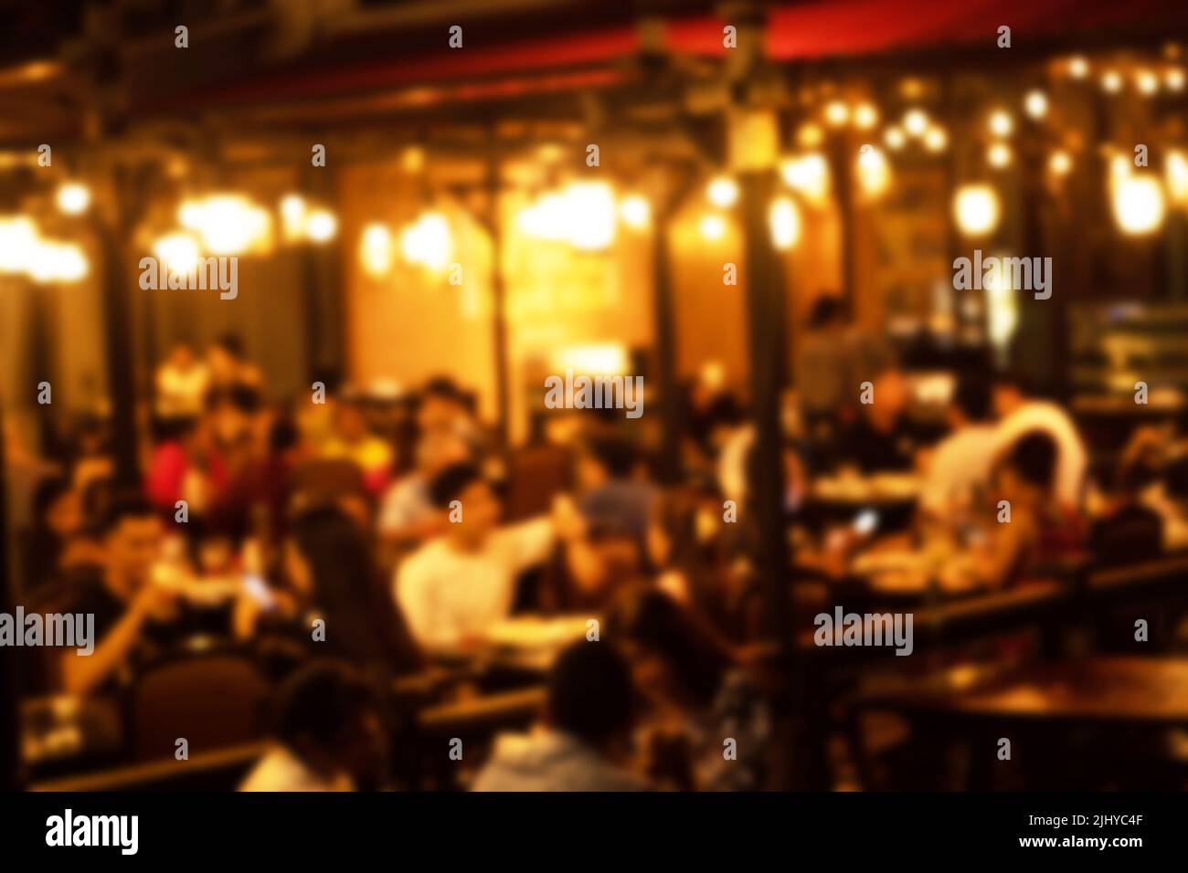 blurred image at the restaurant night time, many people in the ...