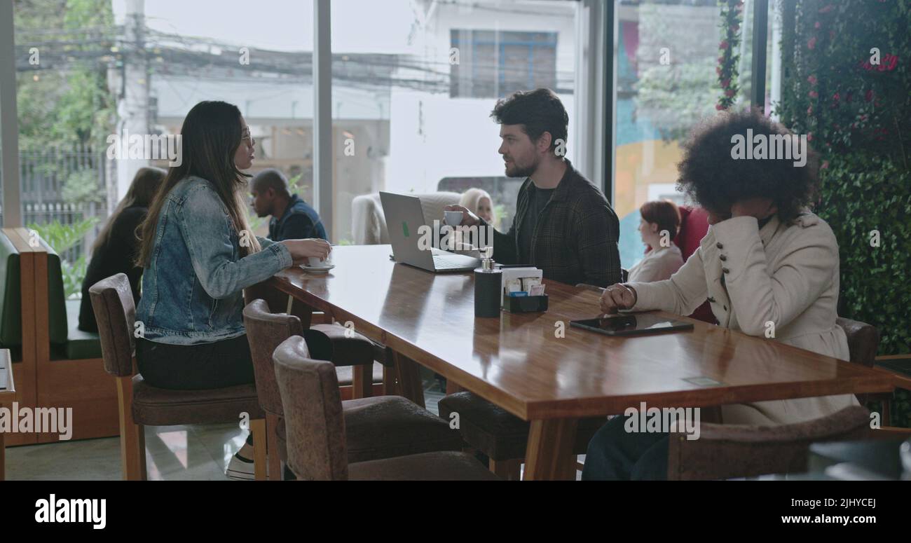 People sitting inside coffee shop drinking cafe. Local business ...