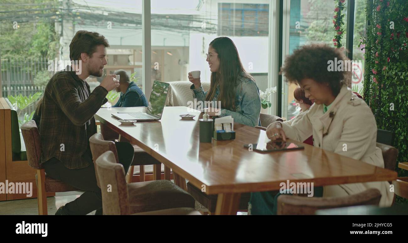People sitting inside coffee shop drinking cafe. Local business ...