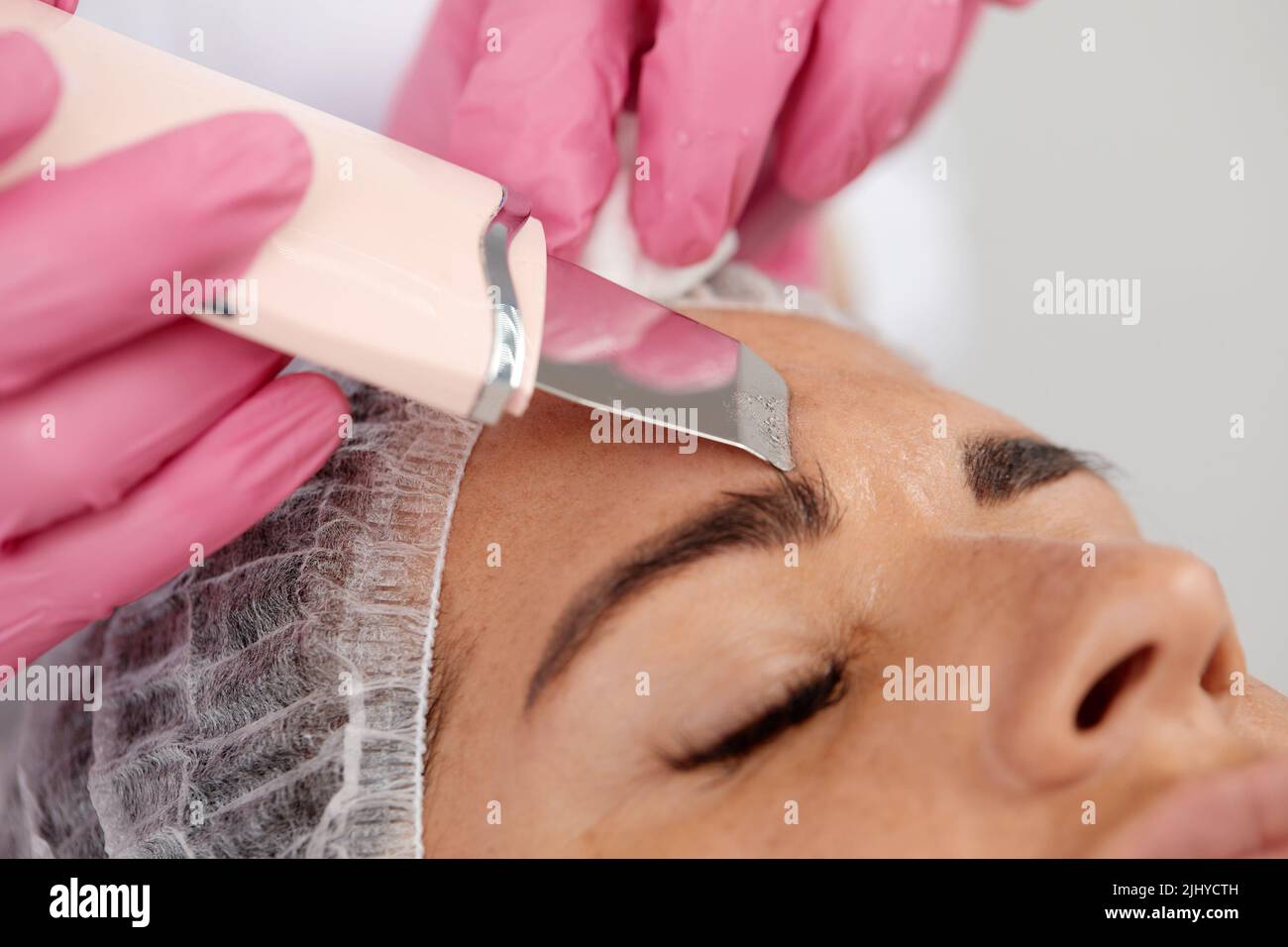 Cosmetologist Beautician In Pink Gloves Making Facial Treatment With