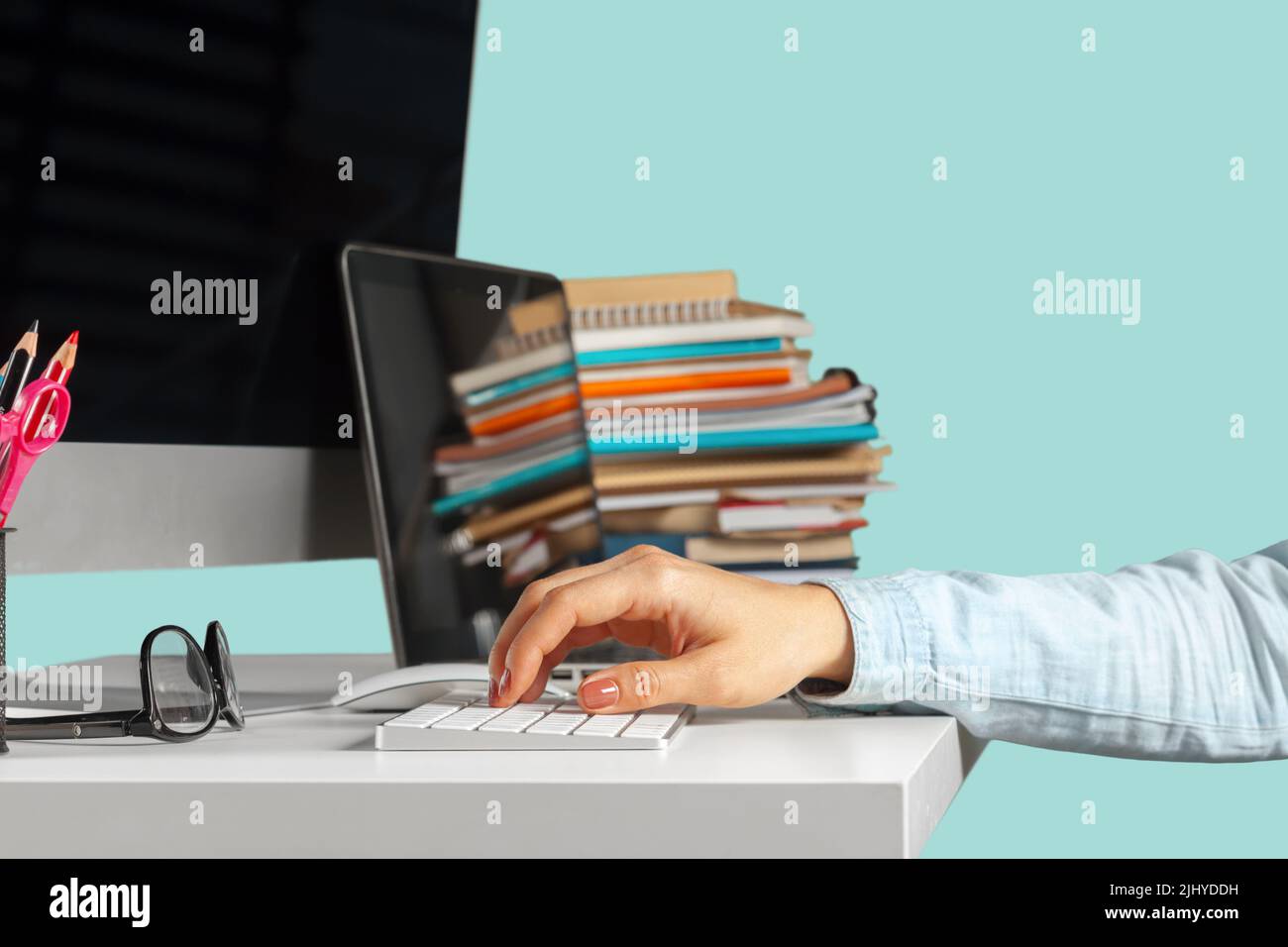 Young woman sitting at the table with open netbook computer. Female ...