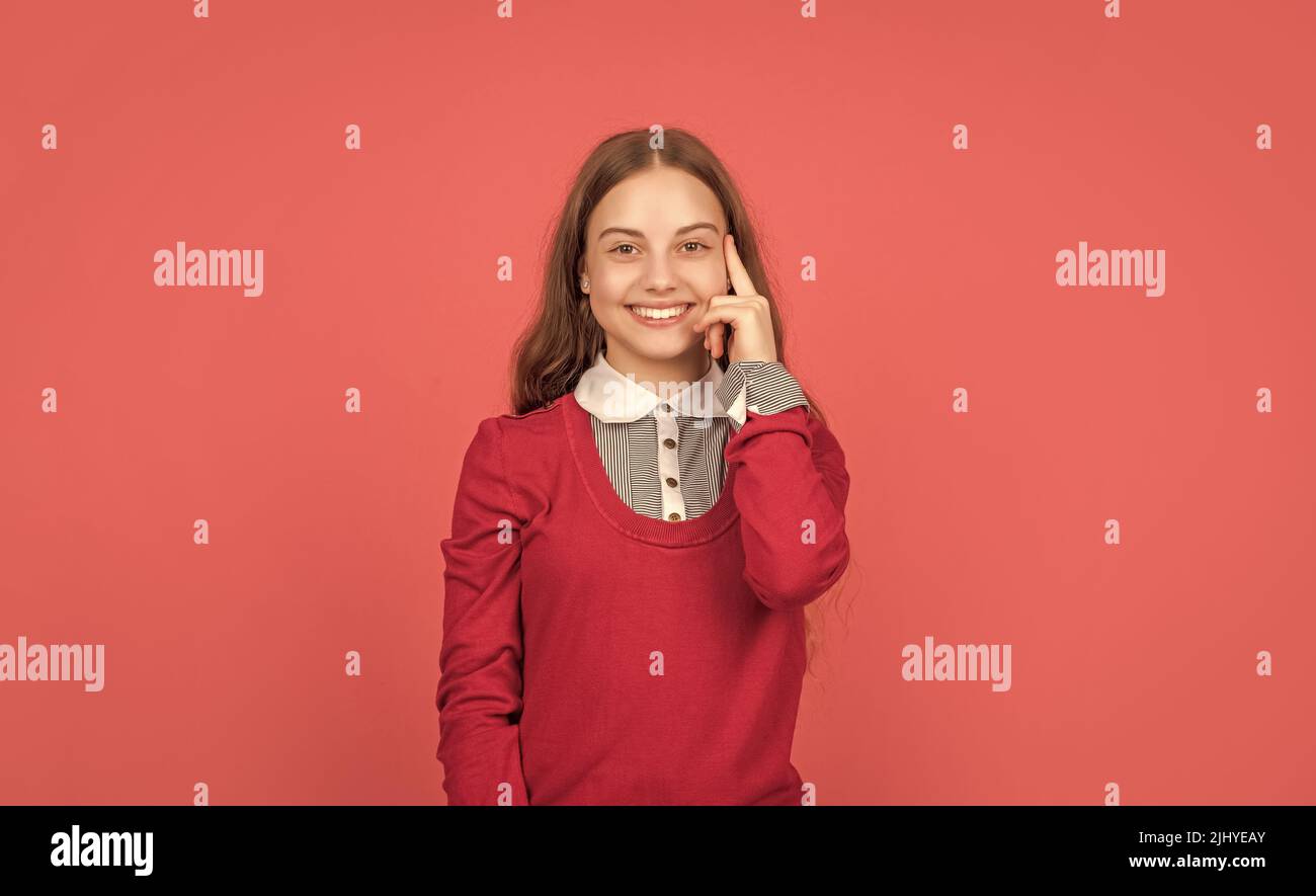 pondering happy kid in school uniform on red background, student Stock ...