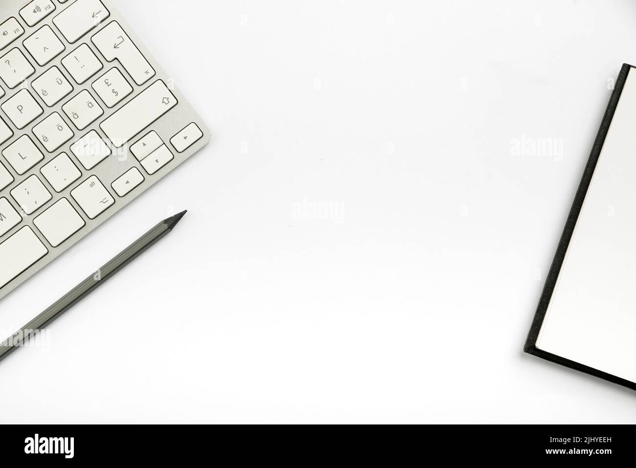 A notepad, pencil, and a part of a white computer keyboard isolated on ...