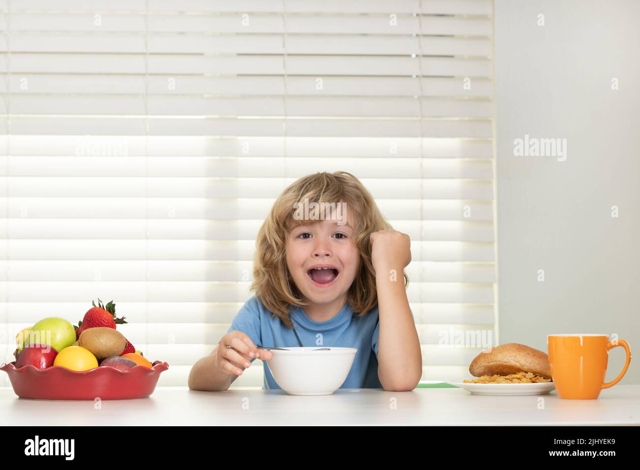 Portrait of preteen child eat fresh healthy food in kitchen at home ...