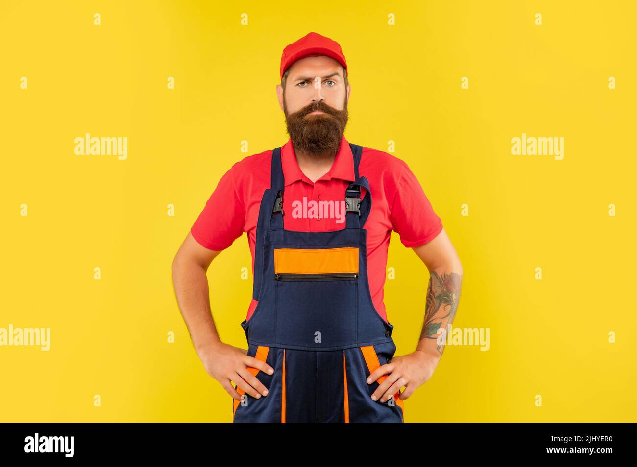 serious bearded man plumber in work clothes on yellow background Stock ...