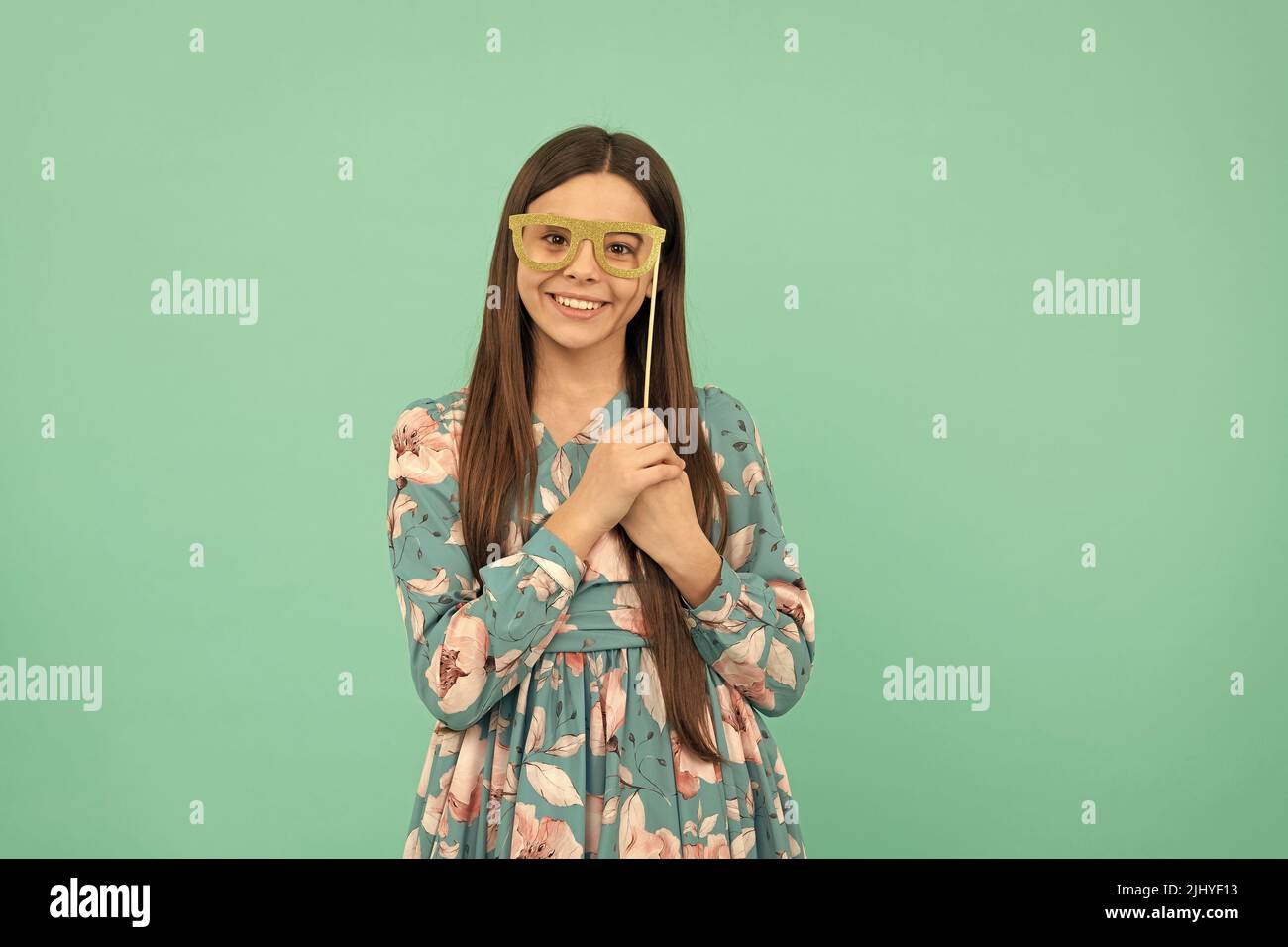 Enjoy the moment. Happy kid smile holding paper glasses. Cool girl ...
