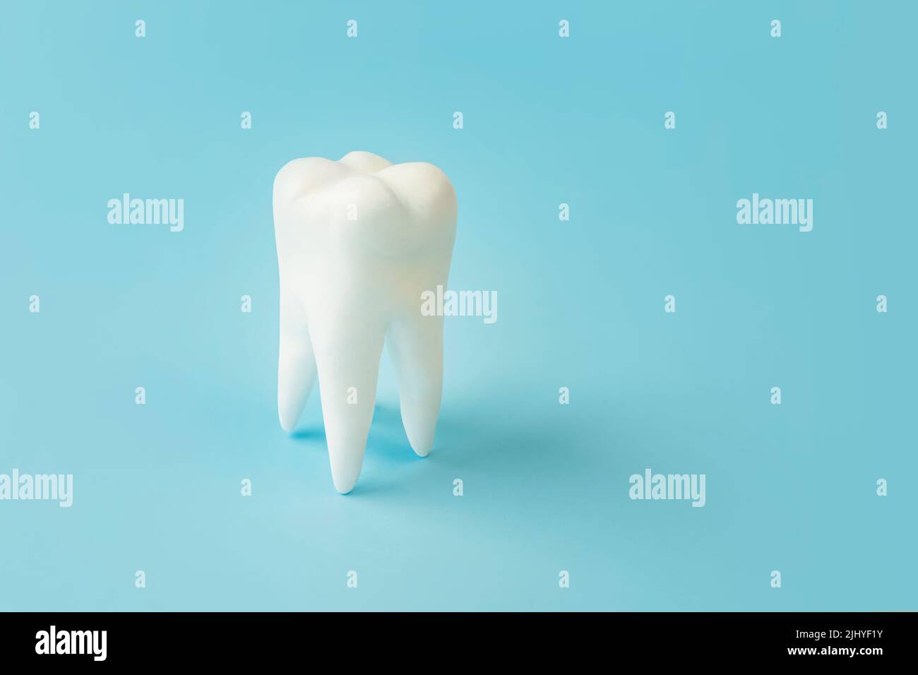 White healthy tooth on blue background with copy space Stock Photo - Alamy