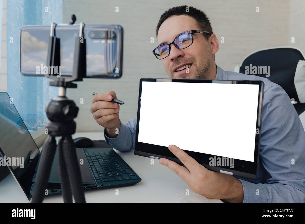 the young man shows an empty white screen on the tablet. Remote ...