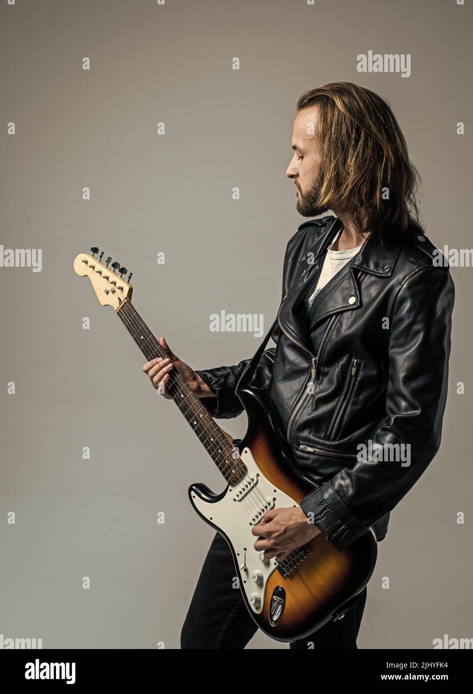 bearded rock musician playing electric guitar in leather jacket, rock ...
