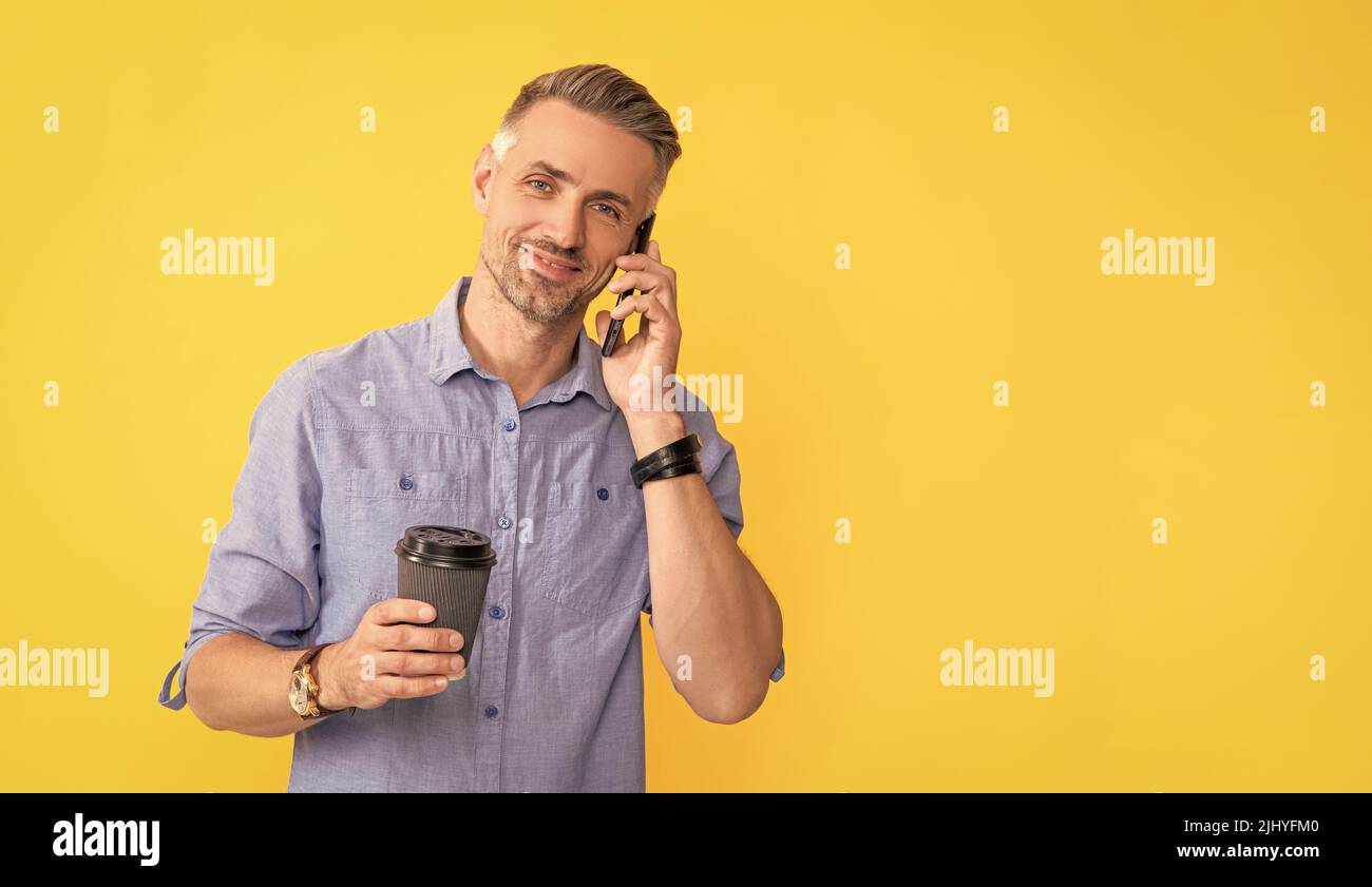 smiling handsome man use smartphone with coffee cup. man drinking ...