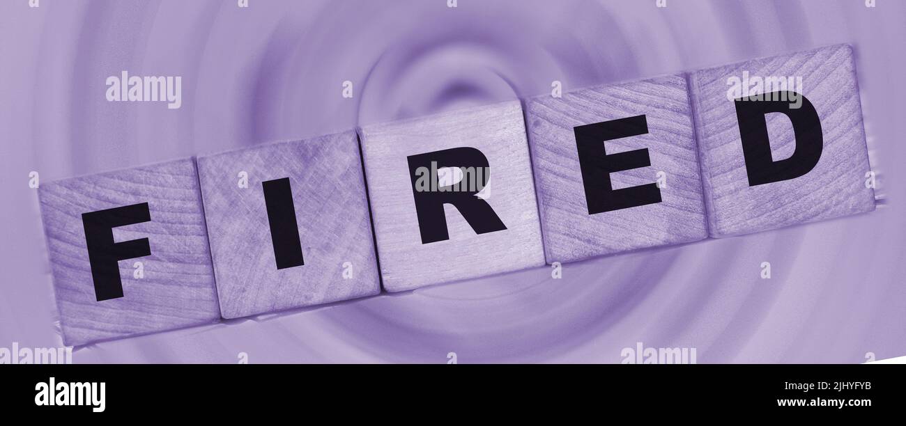 Wooden cubes with word Fired on mosaic border of swimming pool. Cubes with blue letters. Career ...