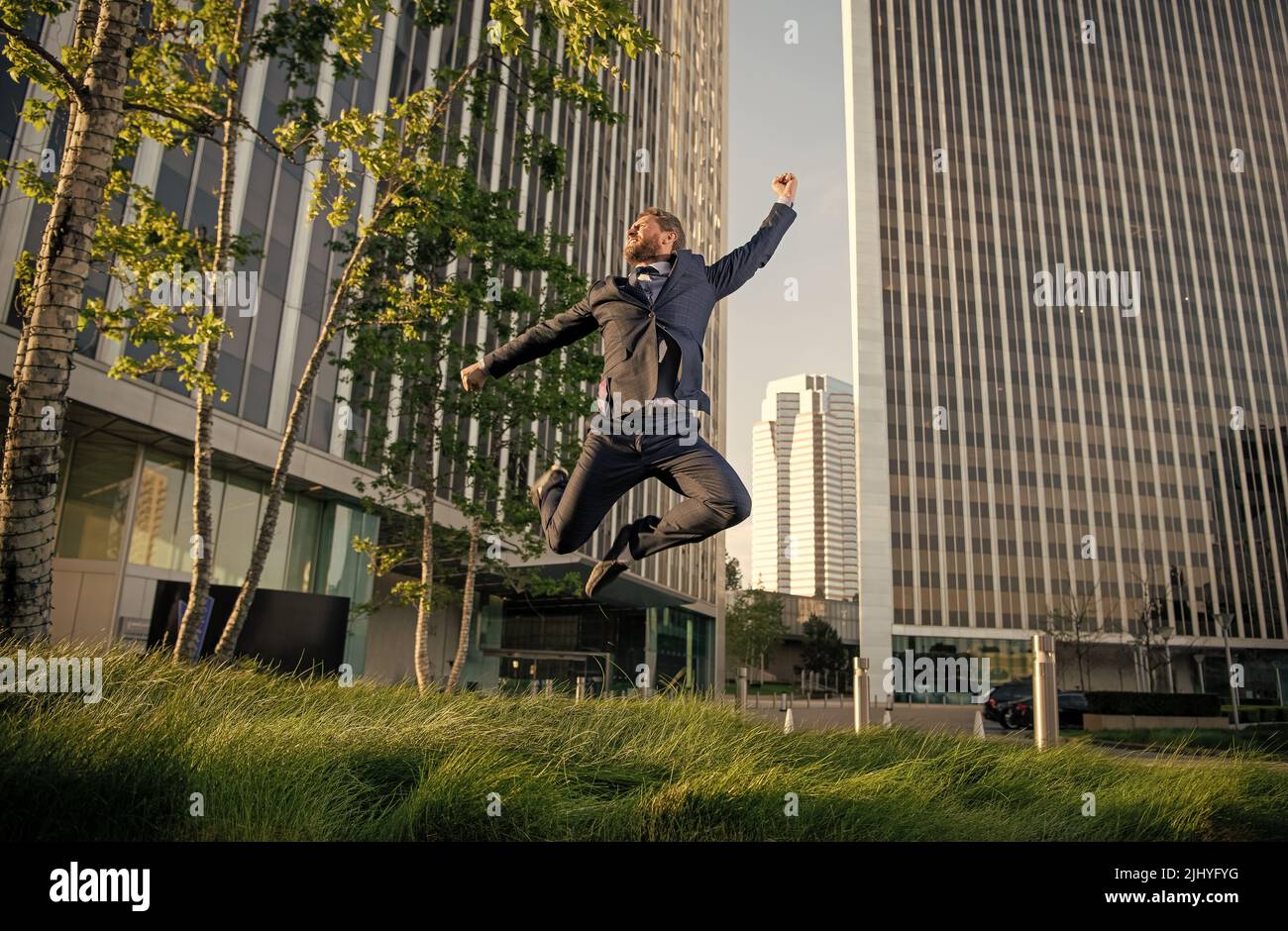happy confident entrepreneur in businesslike suit jump outside the ...