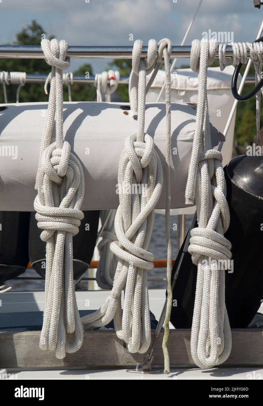 A vertical shot of ropes hanging on the rail of a boat Stock Photo - Alamy