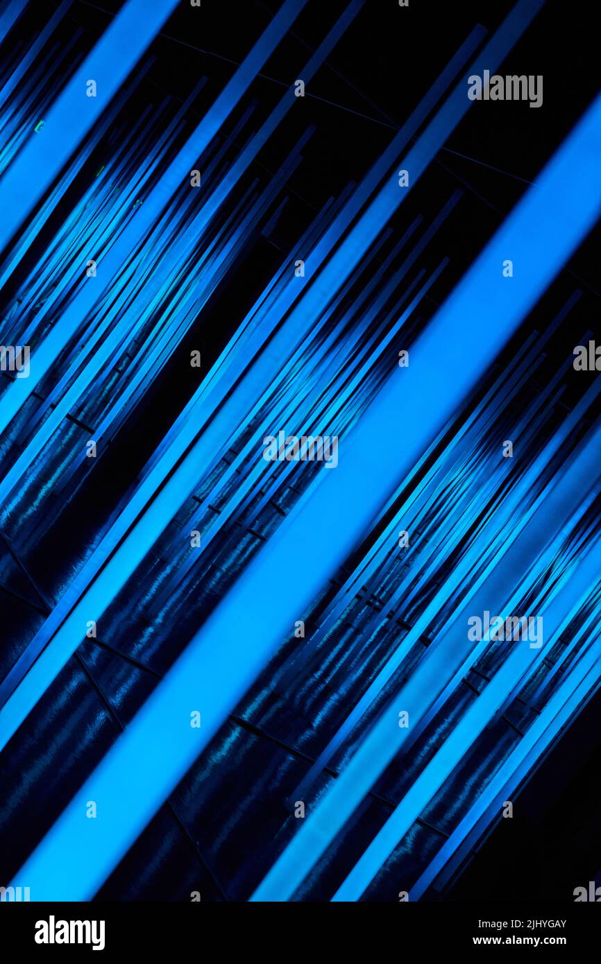 Abstract neon light poles angled in blue Stock Photo - Alamy