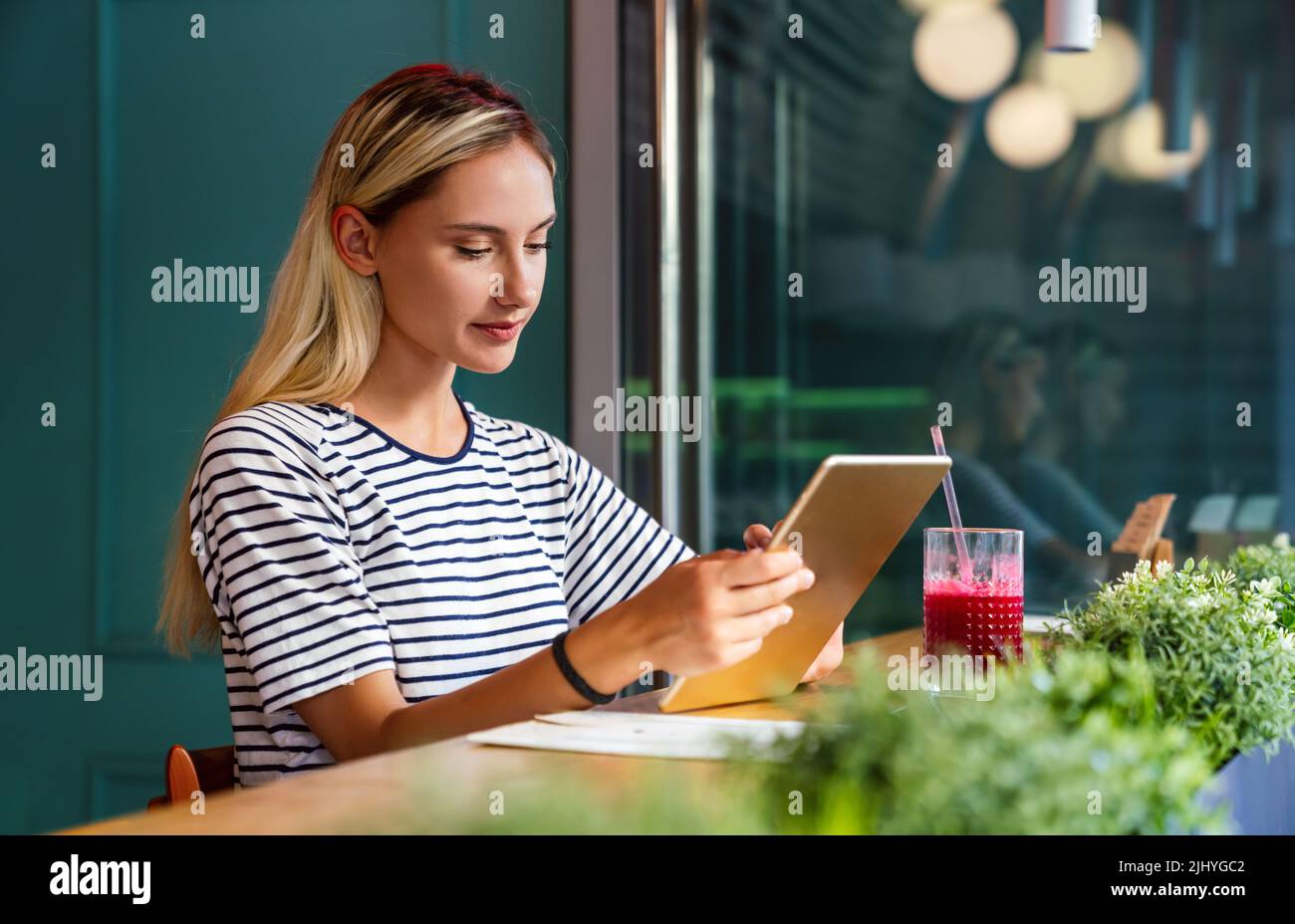Portrait of beautiful young woman using digital device and having fun ...