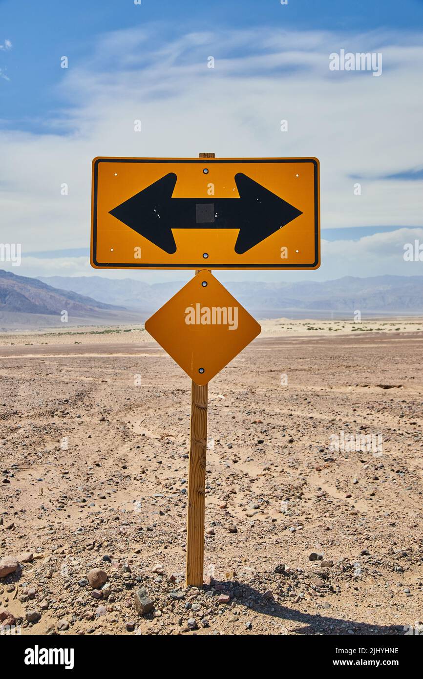 Yellow road sign T intersection left or right in sandy desert Stock ...