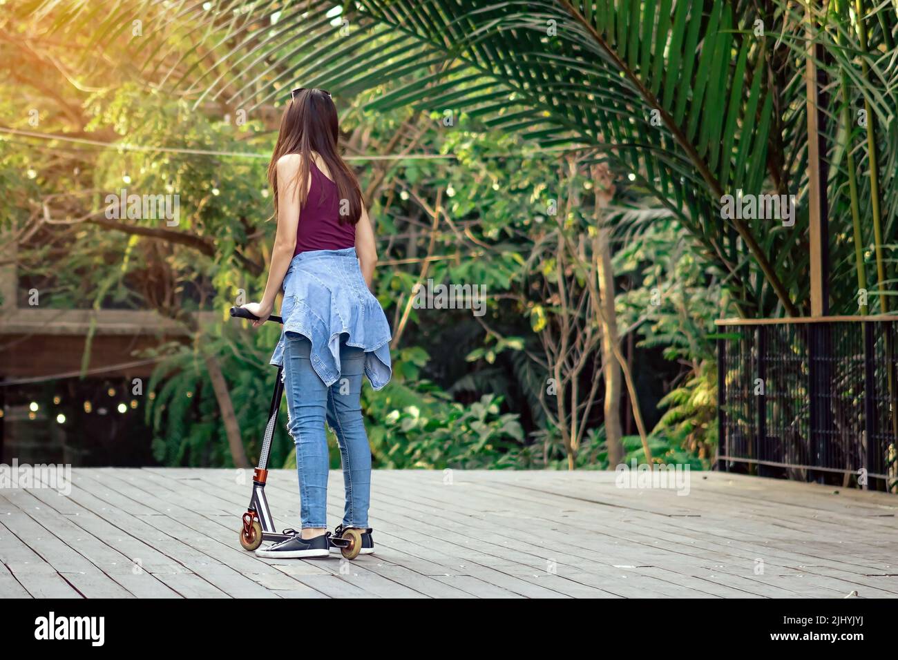 Asian woman enjoy playing and riding modern extreme stunt kick scooter ...