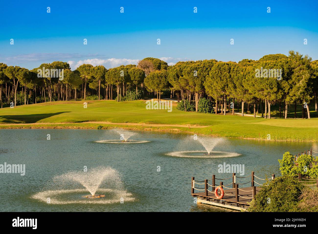 Golf course located behind the lake with fountains Stock Photo - Alamy