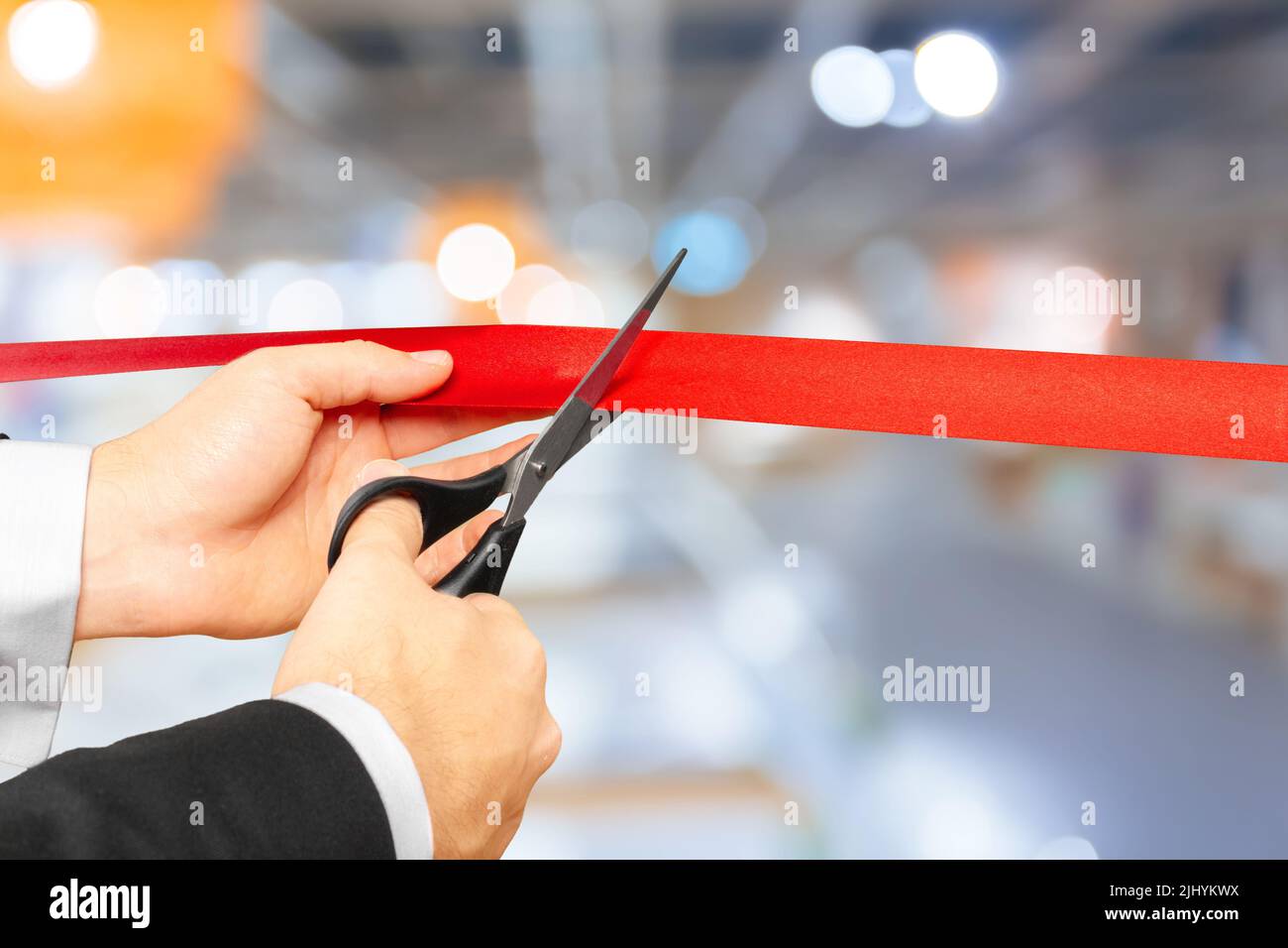 Businessman cutting red ribbon with pair of scissors Stock Photo - Alamy