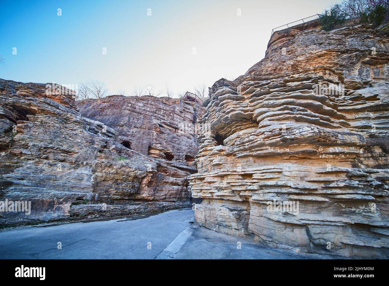 Unique layers of rocks in cliffs by paved path Stock Photo - Alamy
